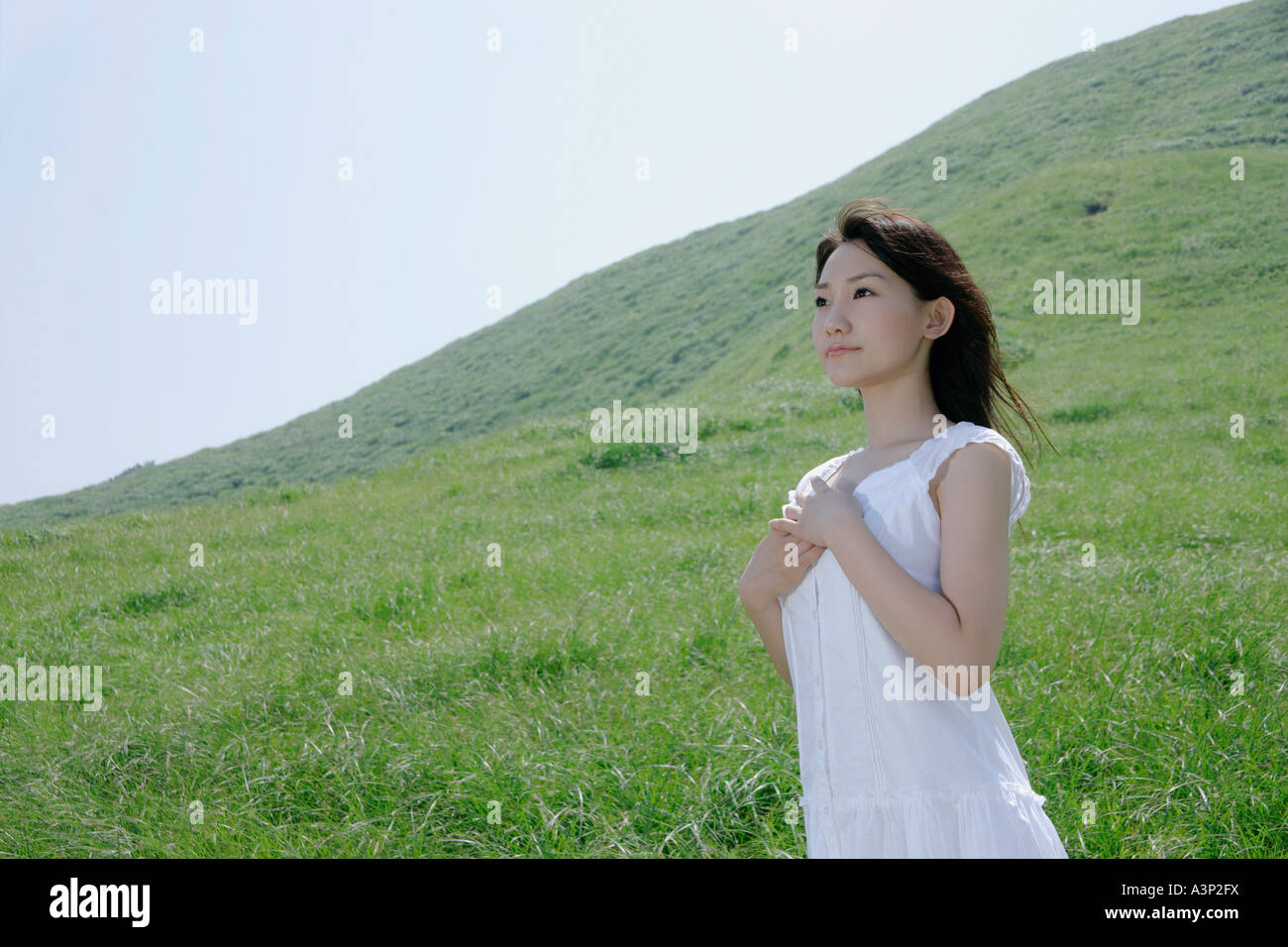 A young woman standing in field Stock Photo - Alamy