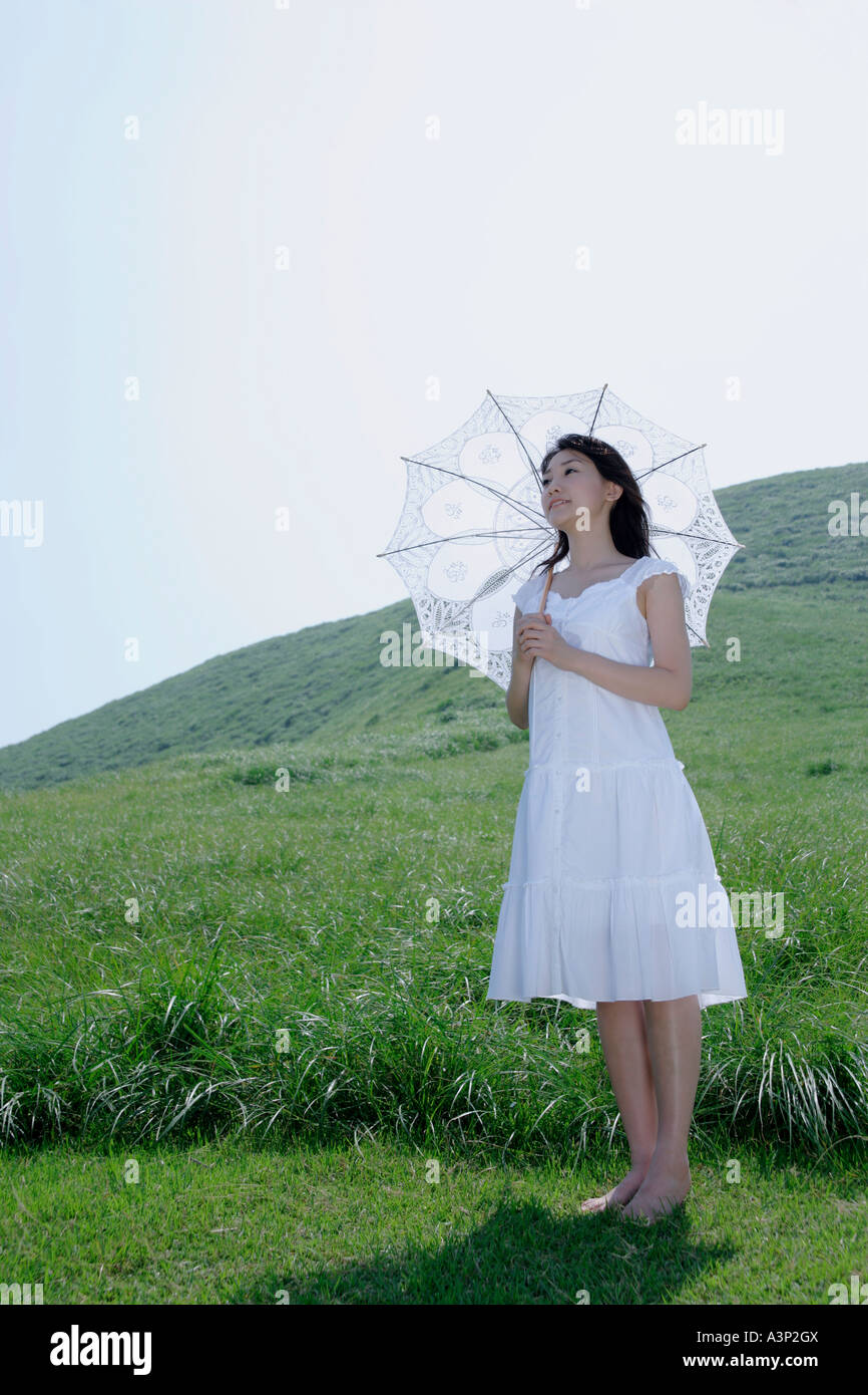 A young woman standing with parasol Stock Photo - Alamy