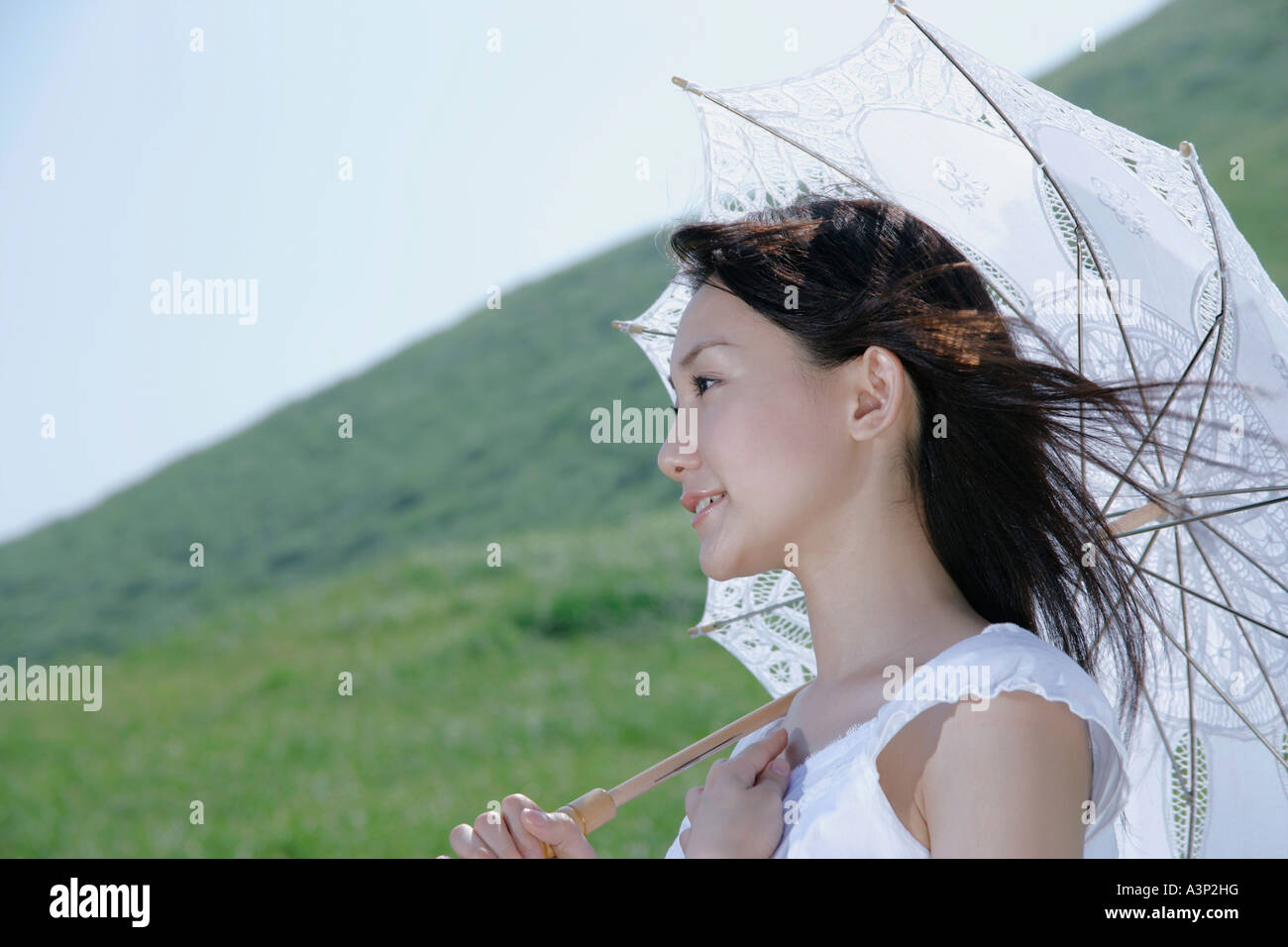 A young woman standing with parasol Stock Photo - Alamy