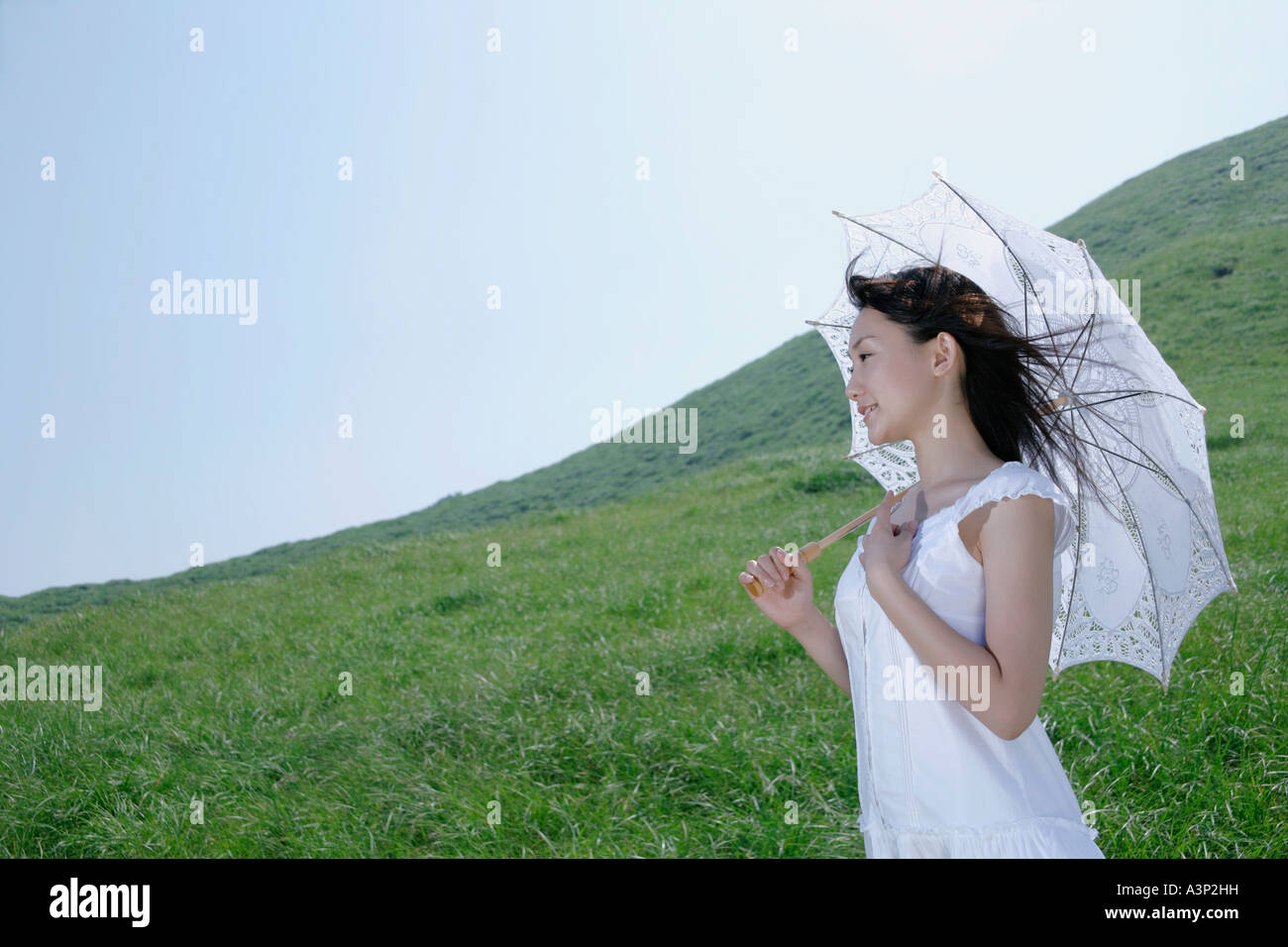 A young woman standing with parasol Stock Photo - Alamy
