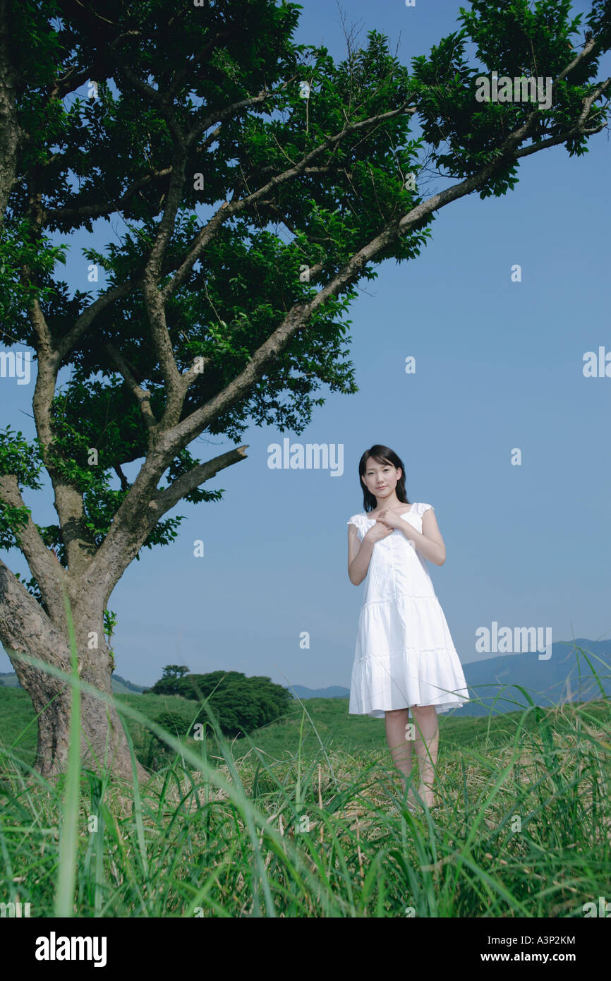 A young woman standing under tree Stock Photo - Alamy