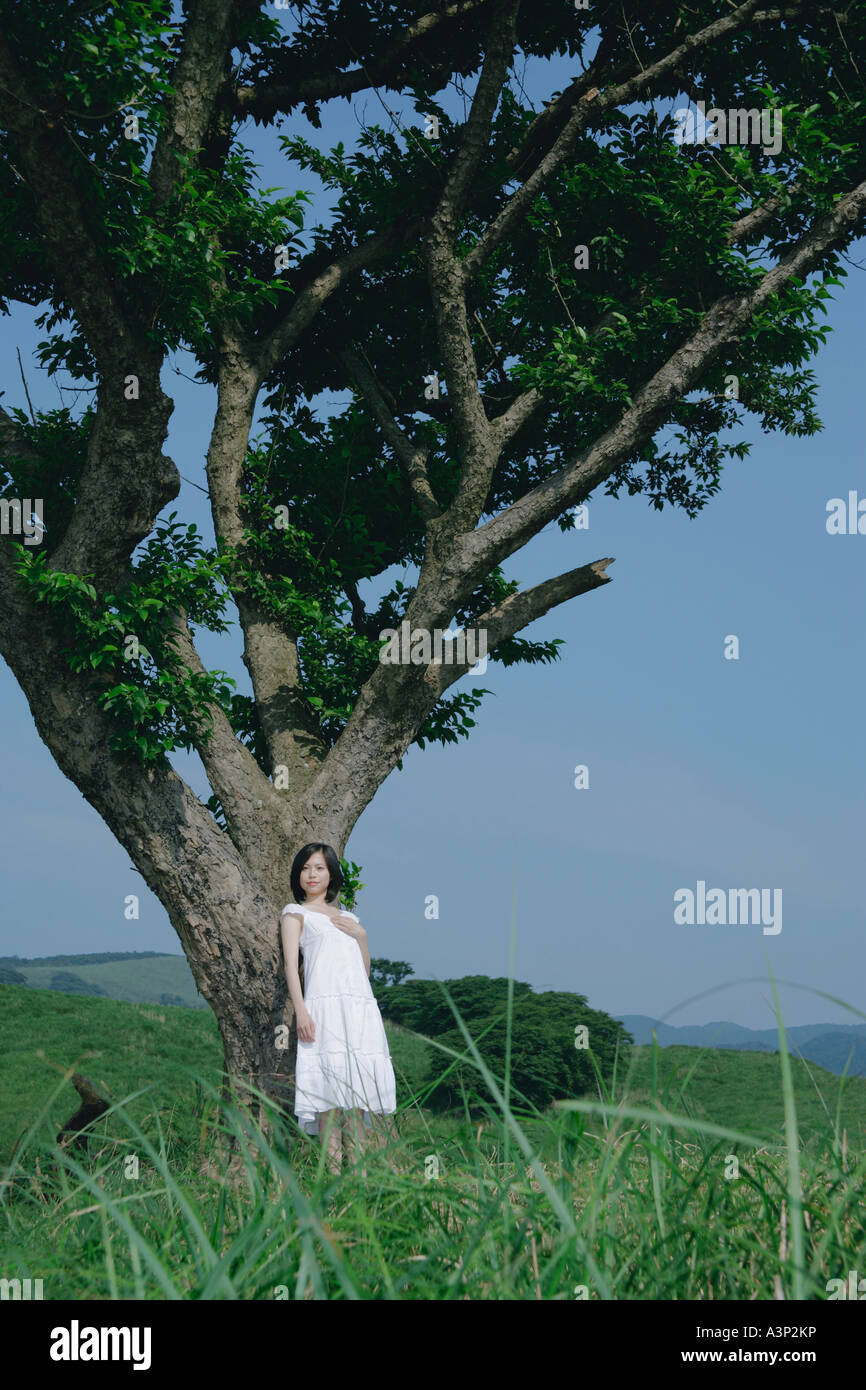 A young woman standing under tree Stock Photo - Alamy