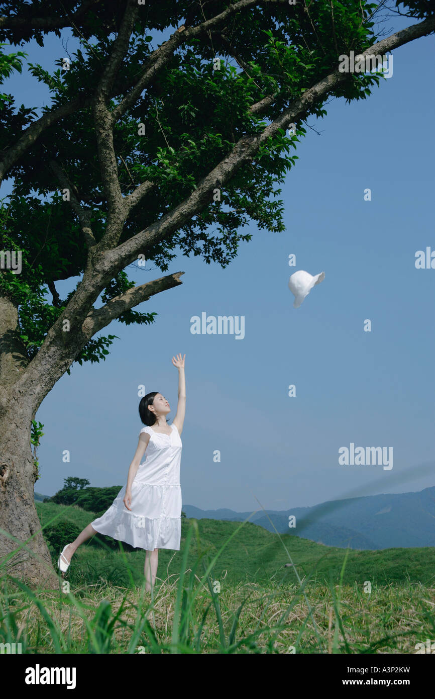 A young woman throwing a hat Stock Photo - Alamy