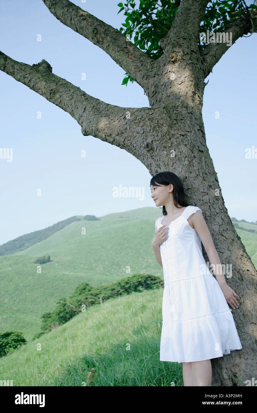 A young woman standing under tree Stock Photo - Alamy