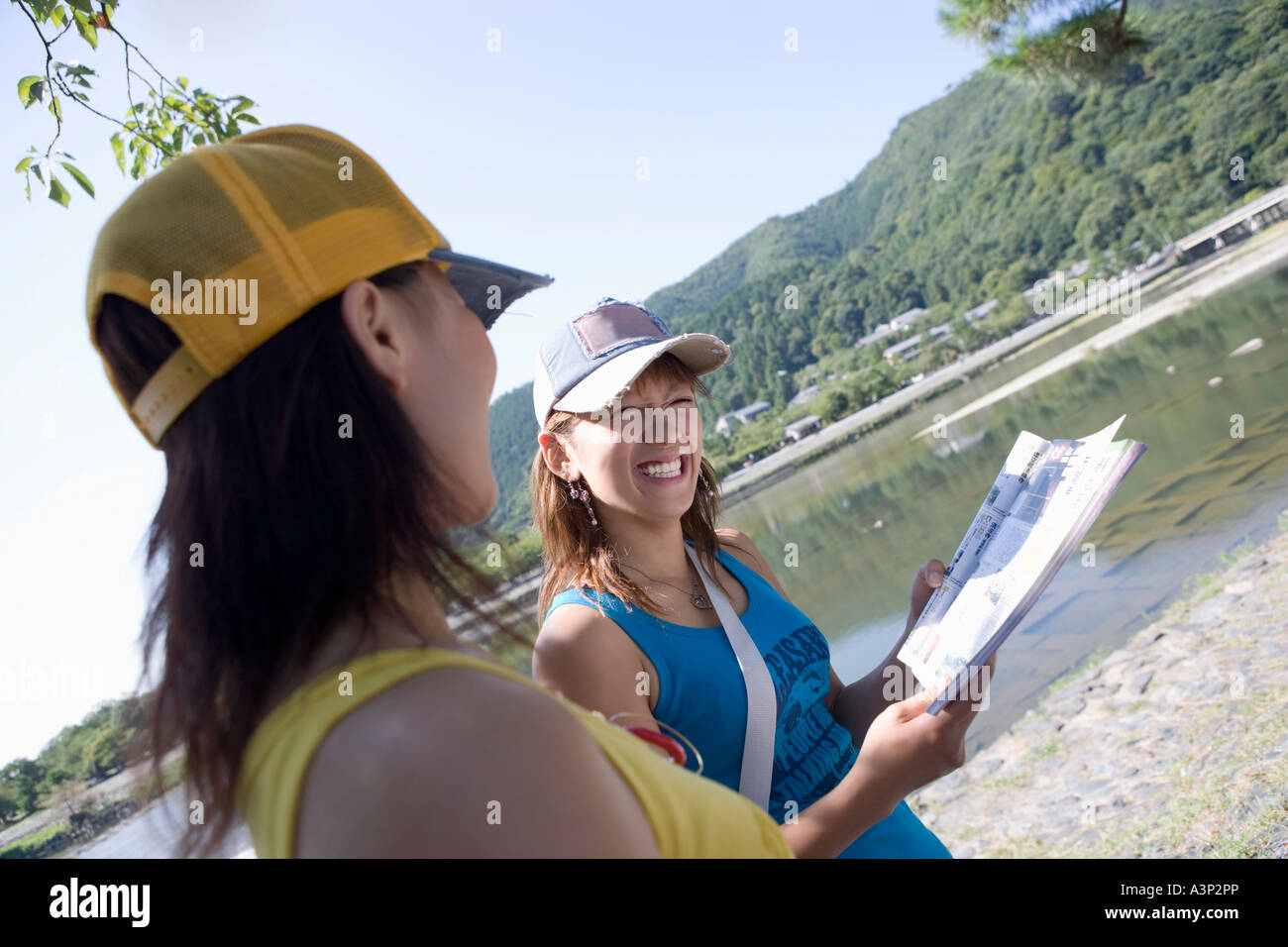 Two young women reading guidebook Stock Photo - Alamy