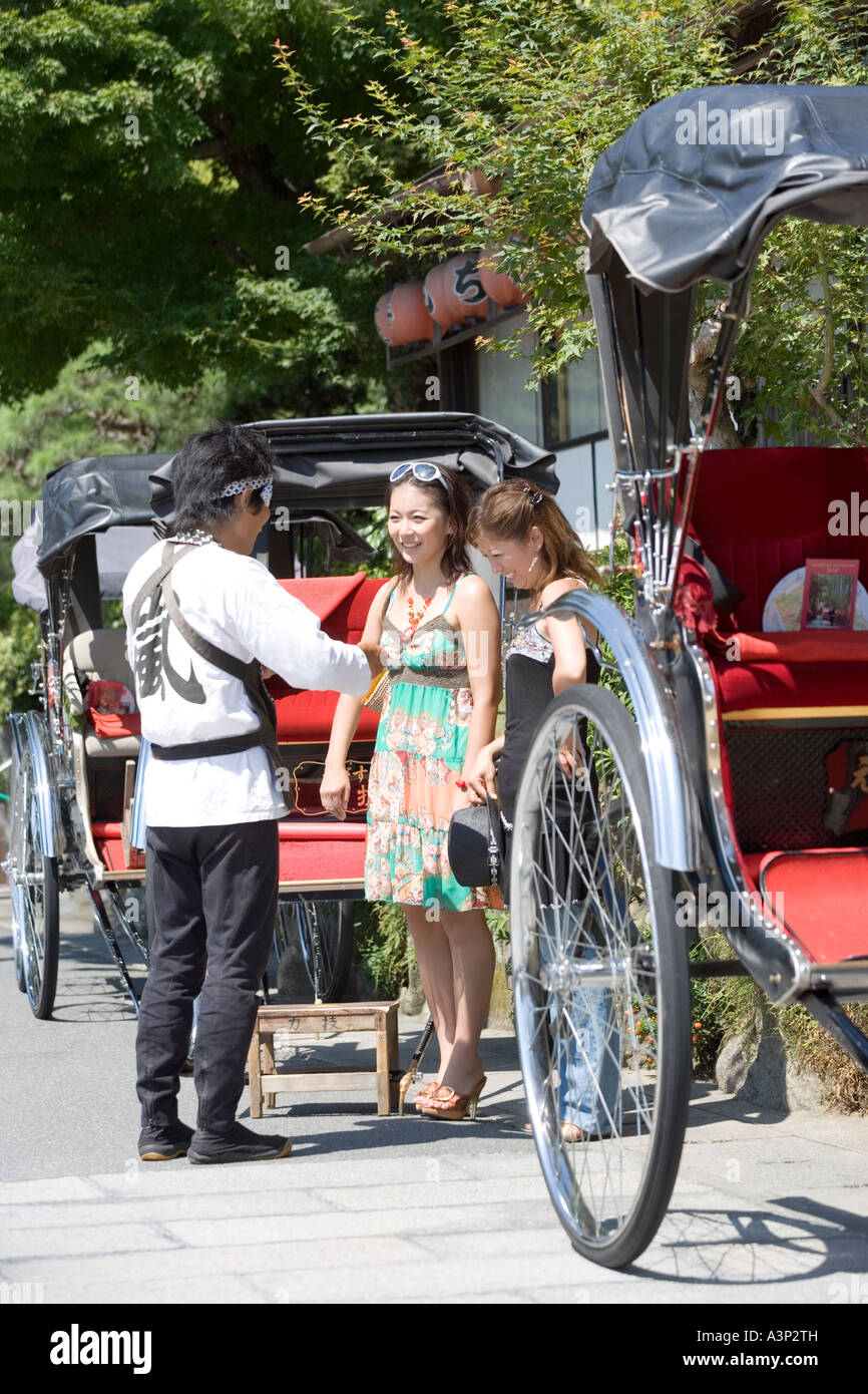 Two young women talking with rickshaw driver Stock Photo - Alamy