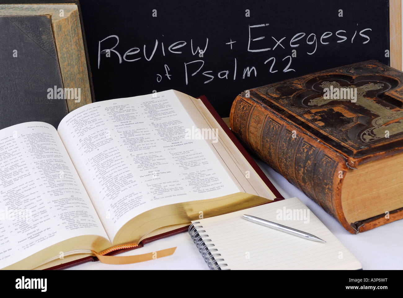 Blackboard notice of school scripture assignment with large bibles, pen ...