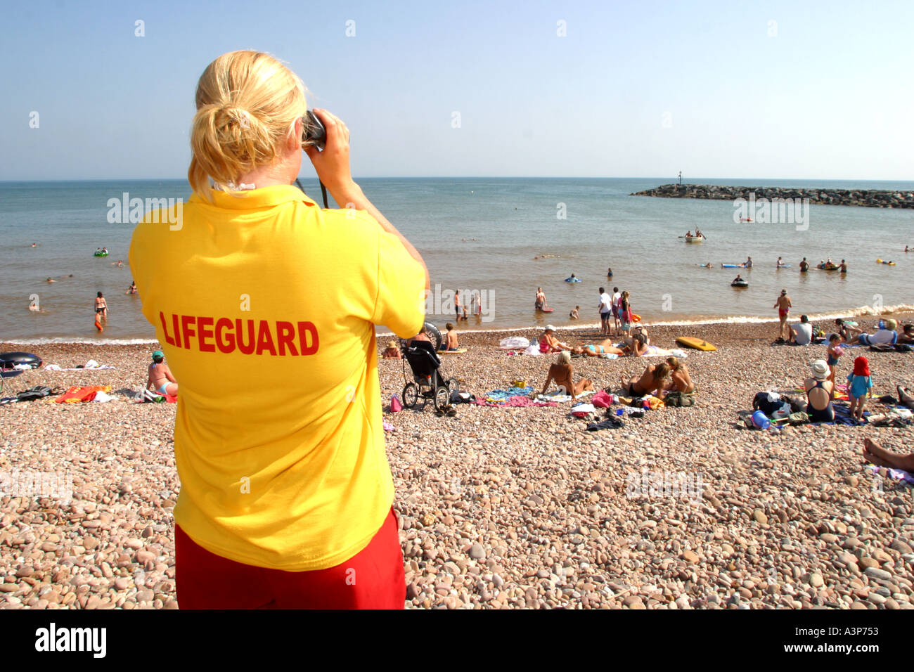 Lifeguard keeps watch on the beach at Sidmouth Devon England Stock ...