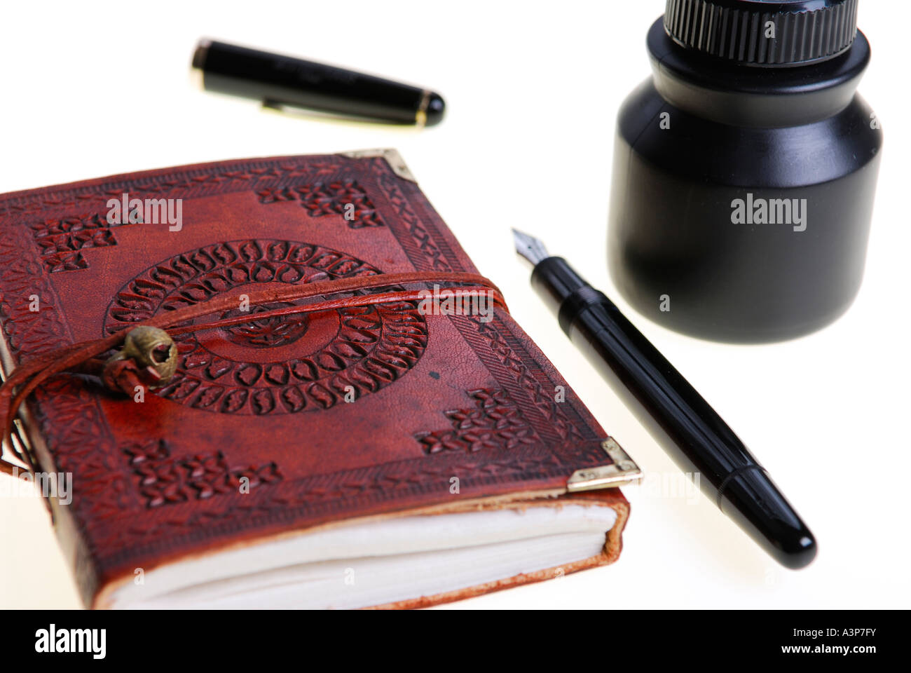 Personal leather diary book and ink with fountain pen on white ...