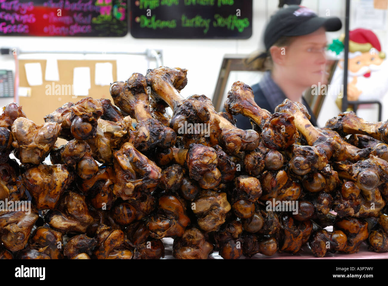 Market server behind a counter stacked with soup bones Stock Photo - Alamy