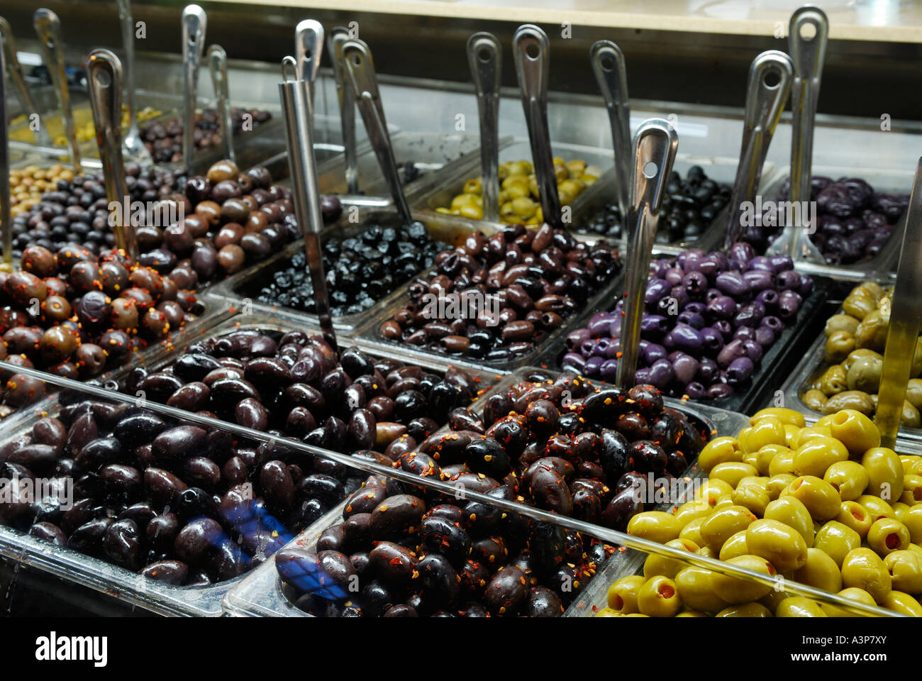Prepared olives at the market with spoons standing up Stock Photo - Alamy