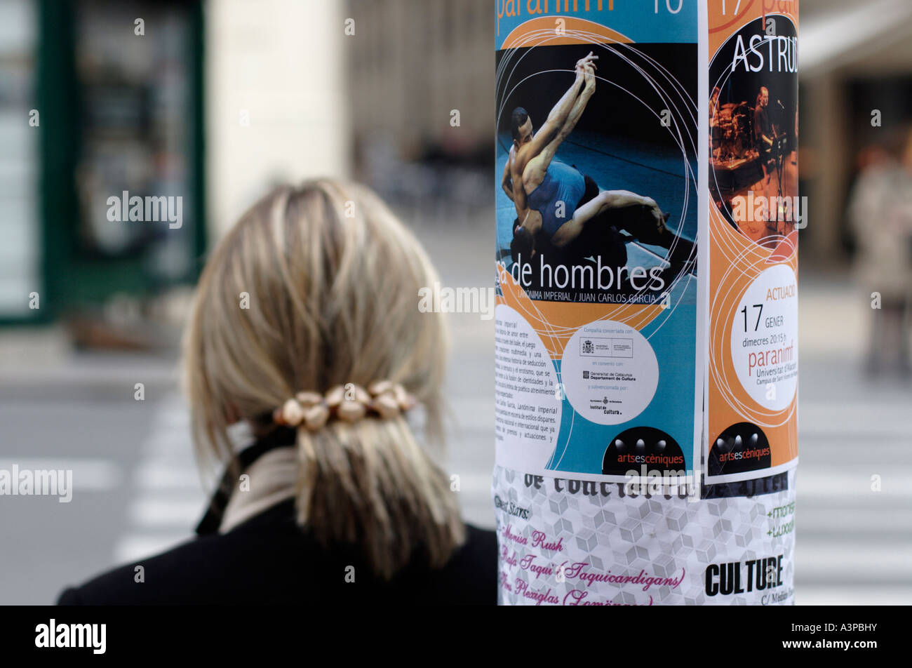 Spanish street fly posters and blond woman Stock Photo - Alamy