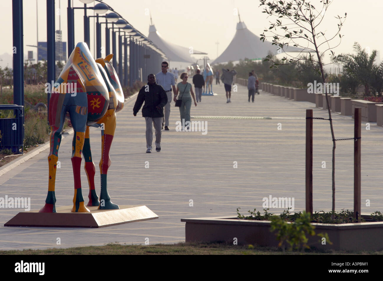 A statue of a camel and walkers in the distance, The Corniche, Abu ...