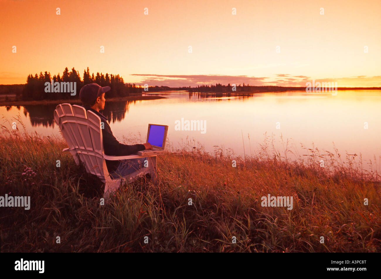 Laptop computer on deck chair at lake sunset Stock Photo - Alamy