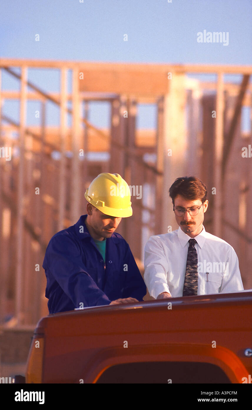 Carpenter and architect looking over blueprints Stock Photo - Alamy