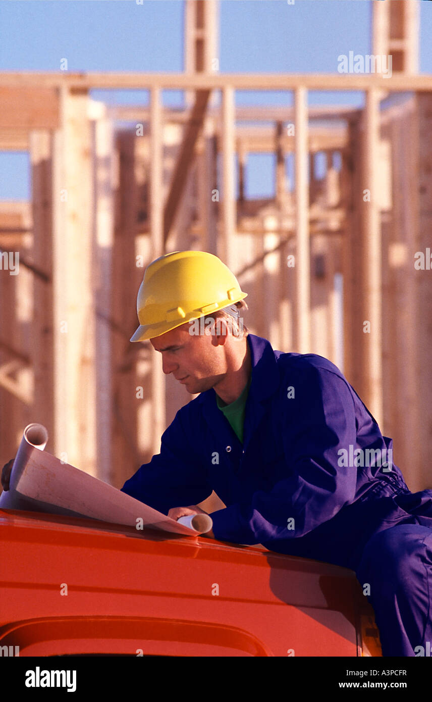 Carpenter looking over blueprints Stock Photo - Alamy
