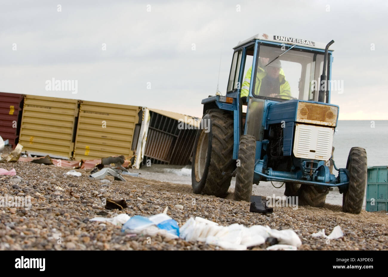 Tractor clearing up rubbish off the beach at branscombe south devon ...