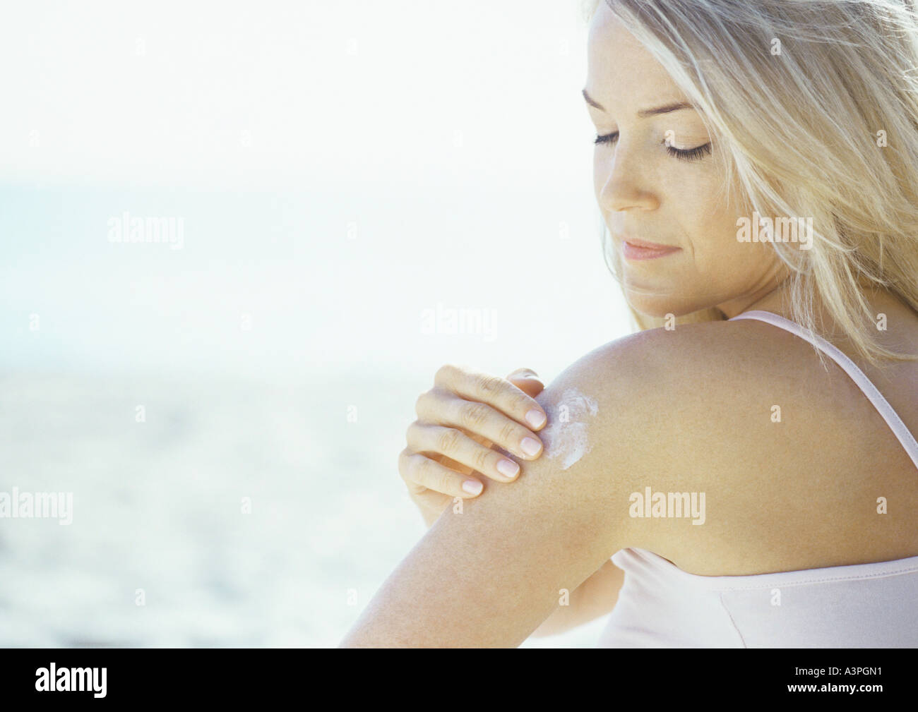 Woman applying sun screen Stock Photo - Alamy
