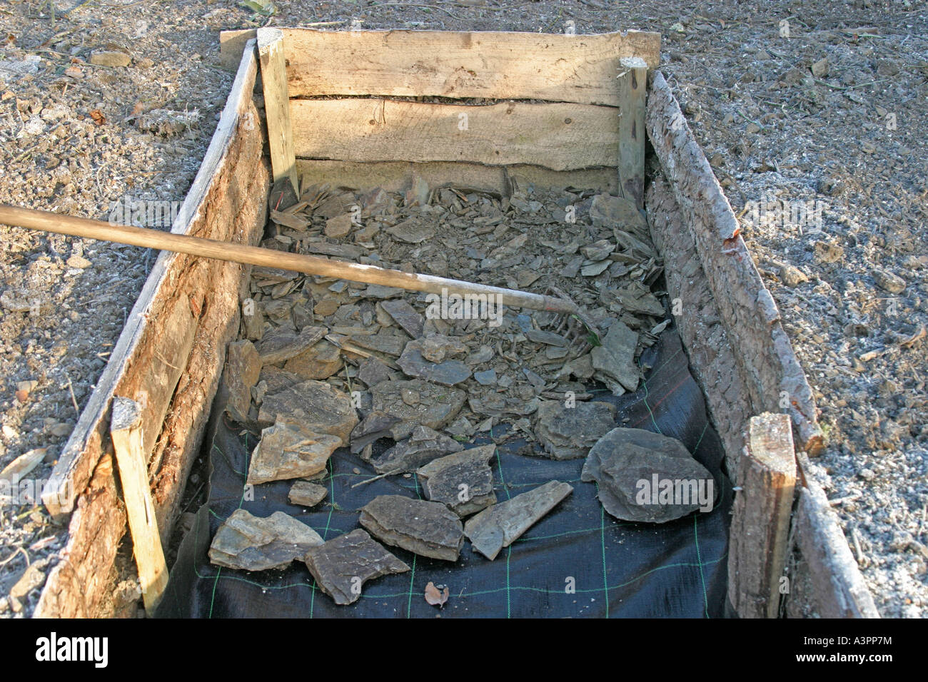 Raised beds paths rake stone level between beds Stock Photo - Alamy