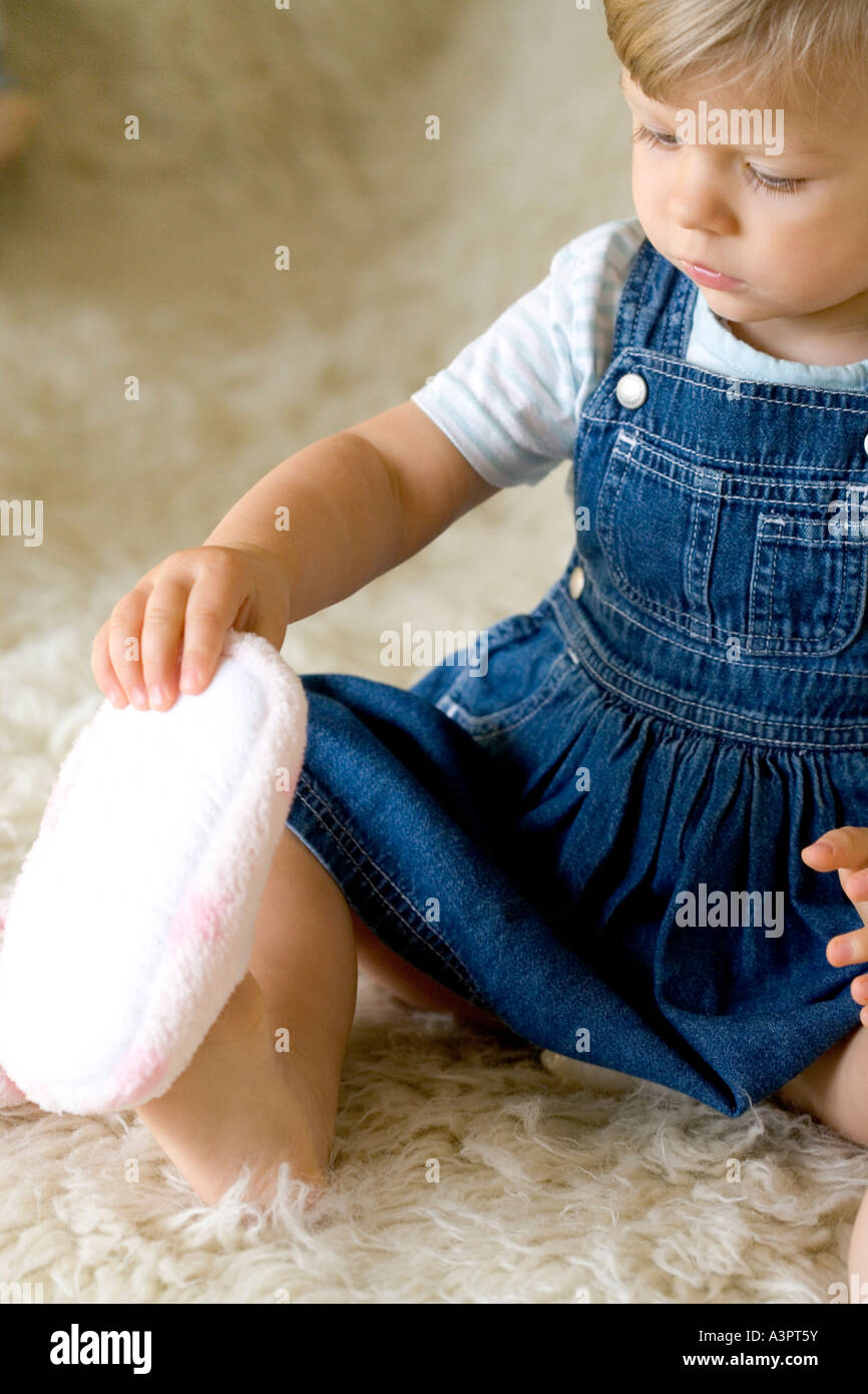 small girl putting on slippers Stock Photo - Alamy