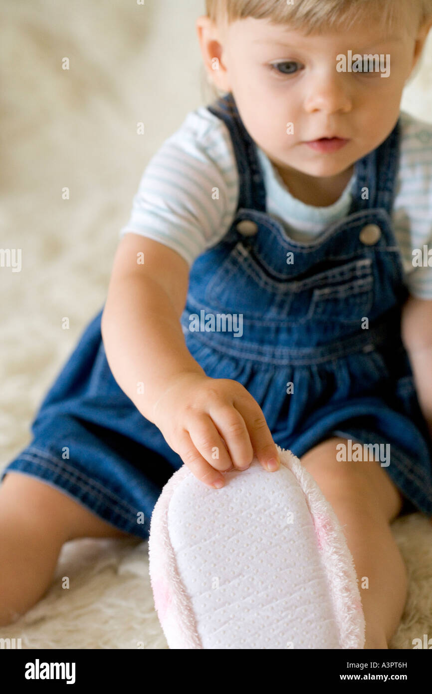 small girl putting on slippers Stock Photo - Alamy