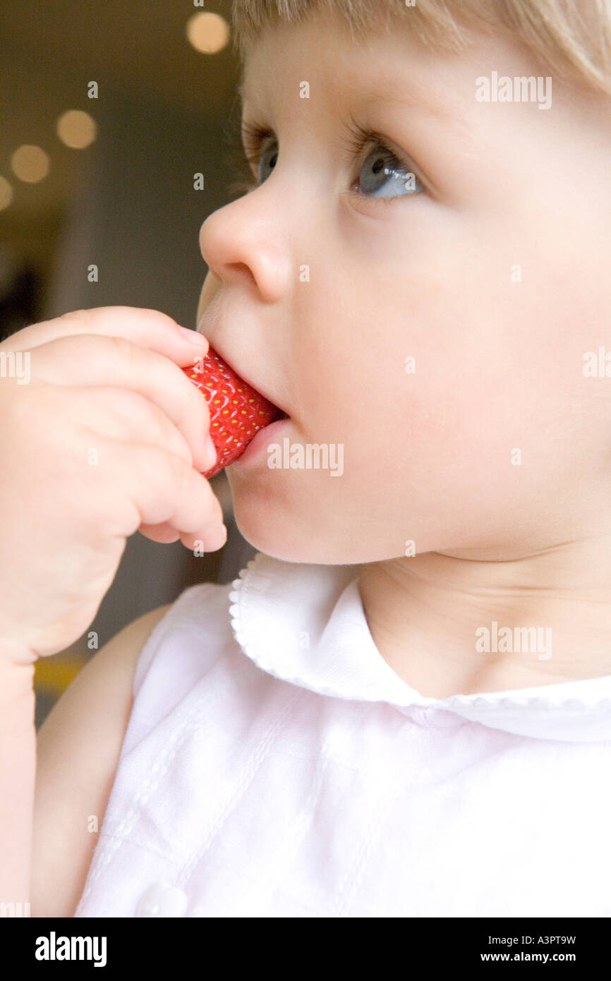 small girl eating strawberry Stock Photo - Alamy