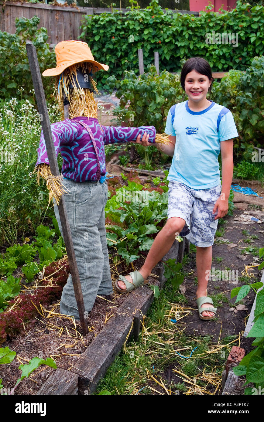 A young girl with the scarecrow she has made to protec her healthy ...