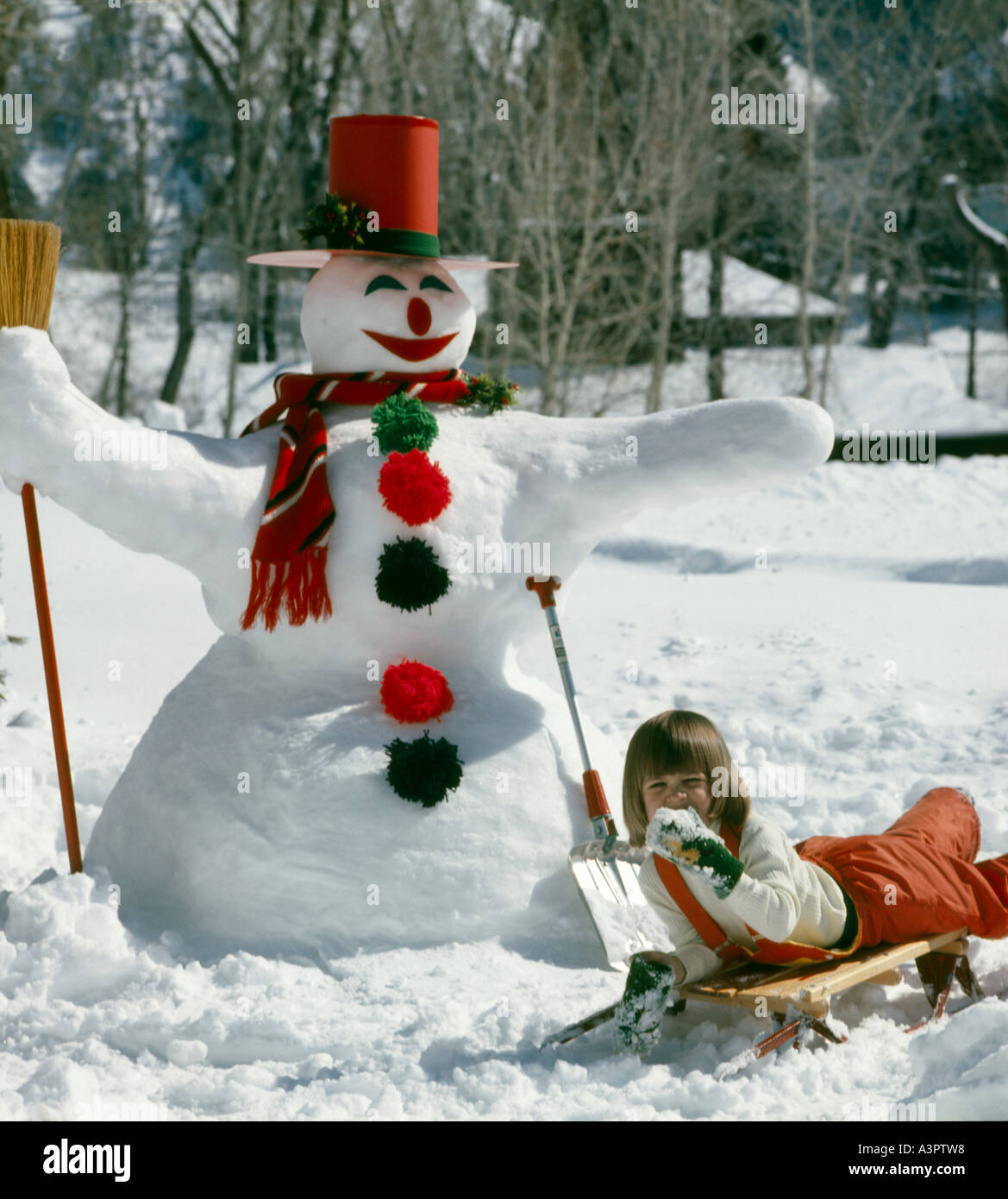Young girl takes a break after completing decorating a jaunty snowman ...