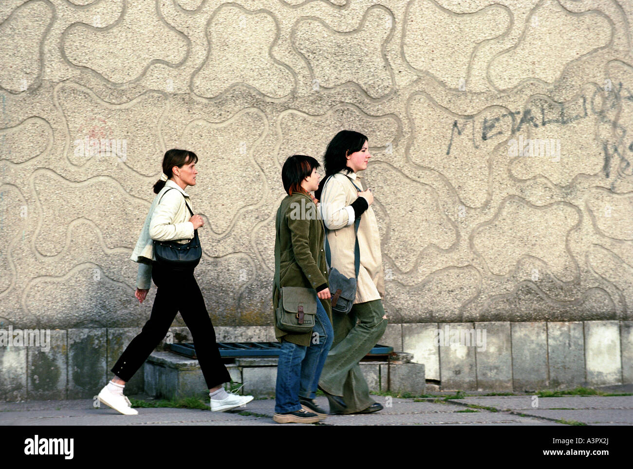 Three women walking along a concrete wall, Kaliningrad, Russia Stock ...