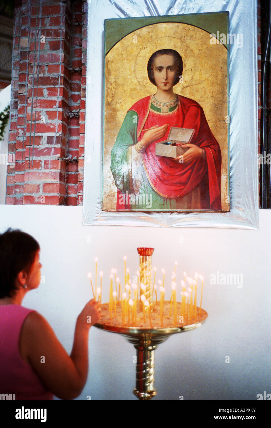 Woman lighting candles in the Cathedral of Christ the Saviour in ...
