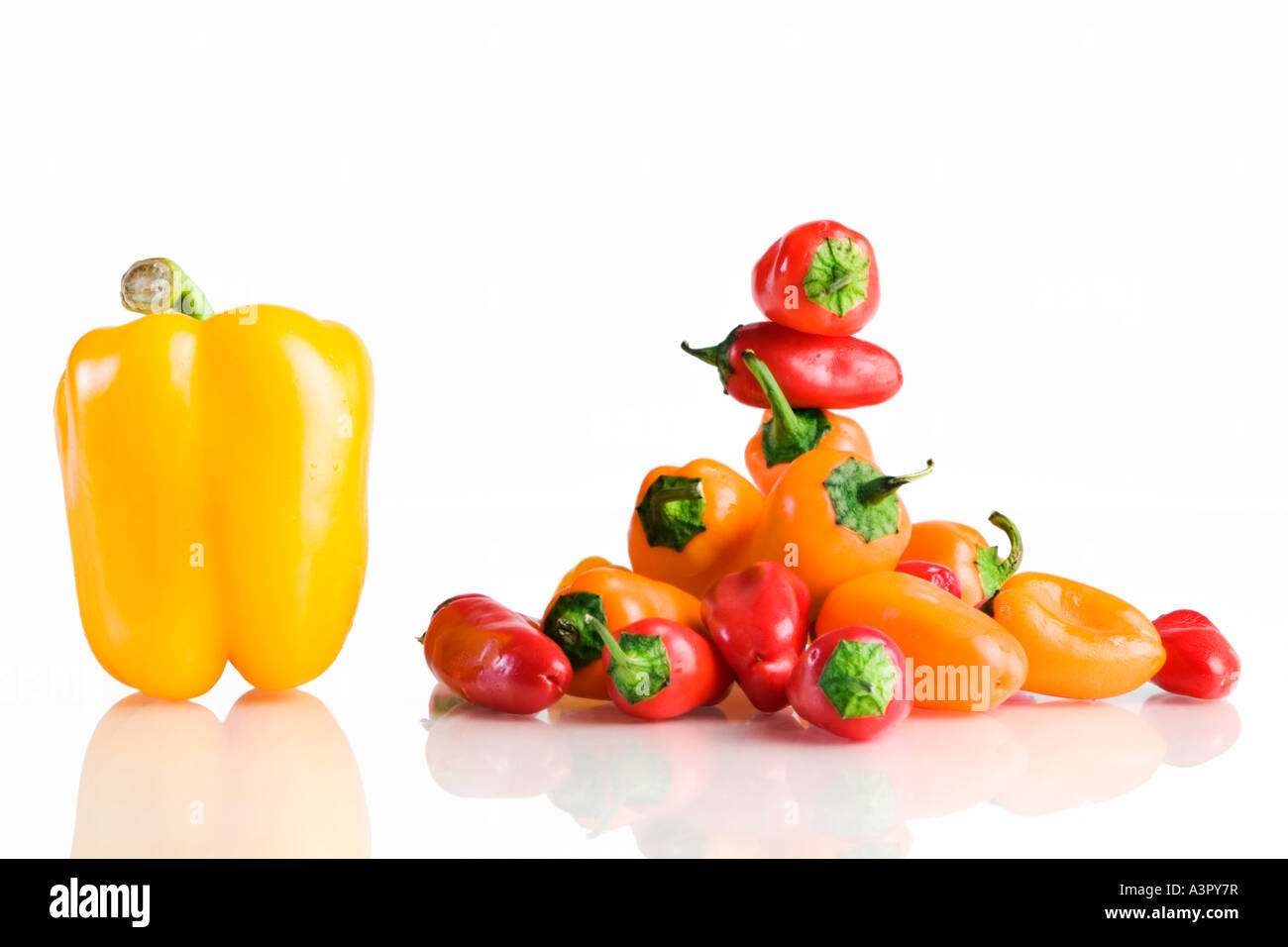 Large bell pepper next to a pile of small peppers Stock Photo - Alamy