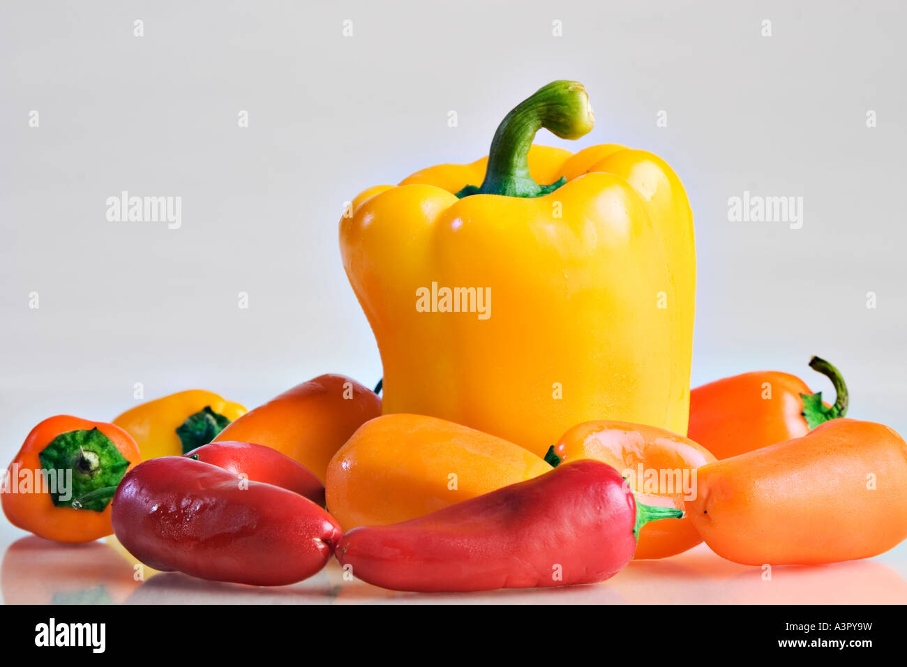 Small peppers surrounding a large bell pepper Stock Photo - Alamy