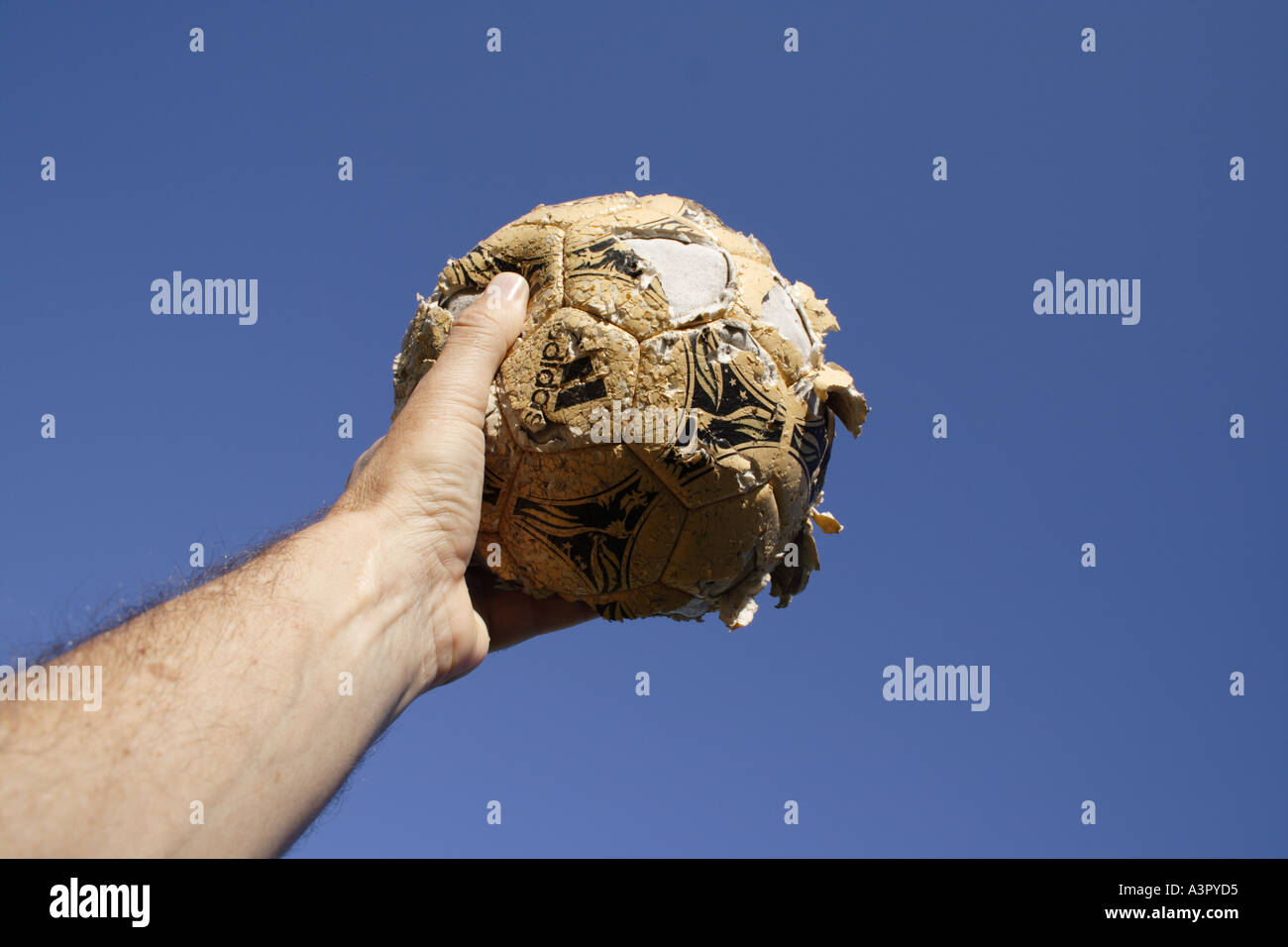 A CHEWED UP SOCCER BALL HELD ALOFT Stock Photo - Alamy