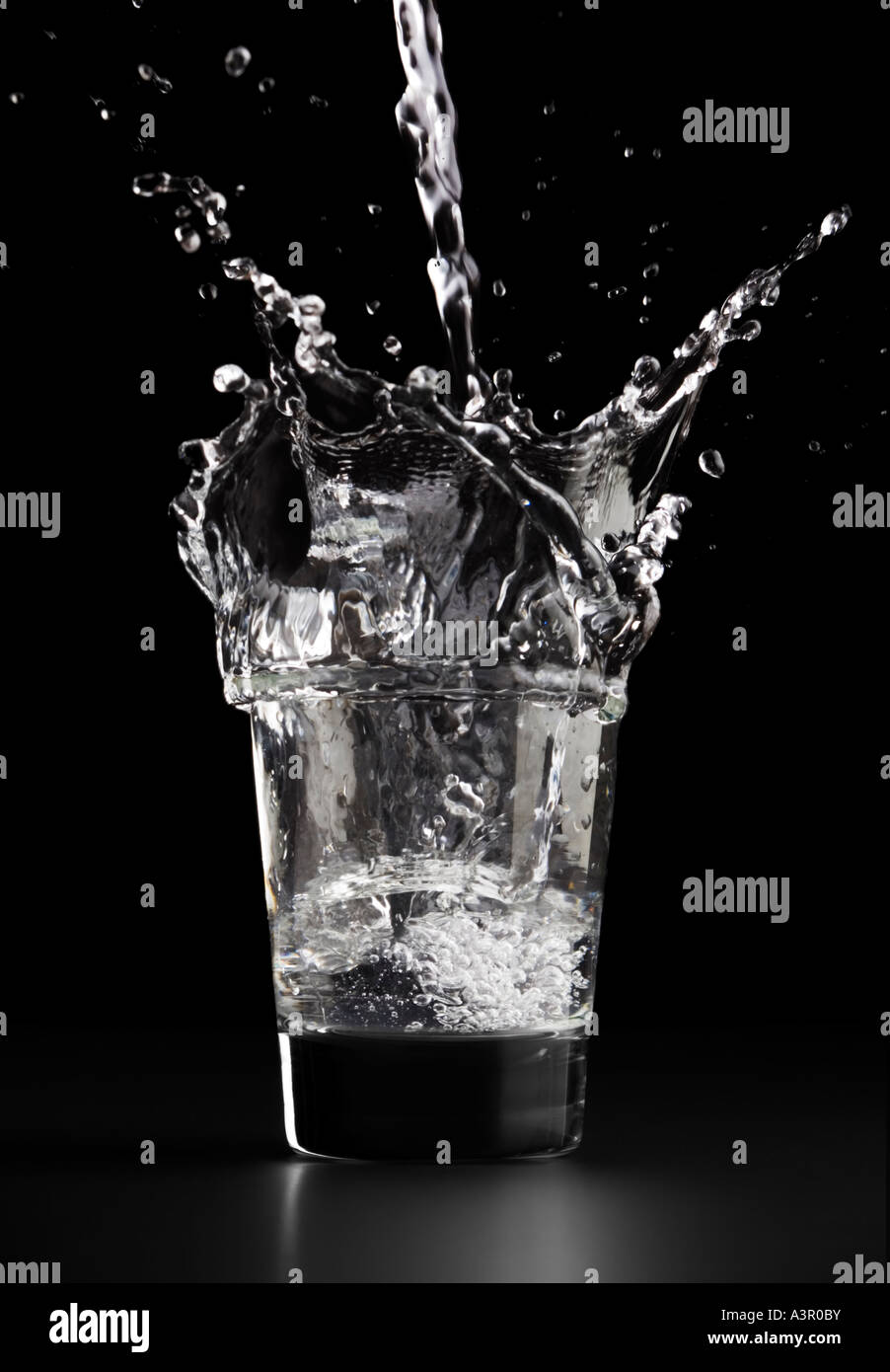 Pouring a glass of water, water splashing out of the glass Stock Photo ...