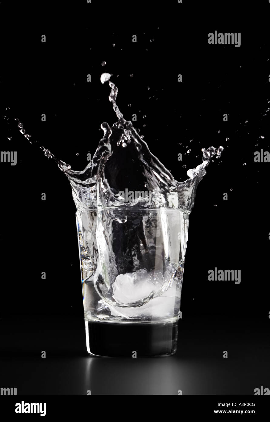 Water splash, dropping an ice cube into a glass of water Stock Photo - Alamy