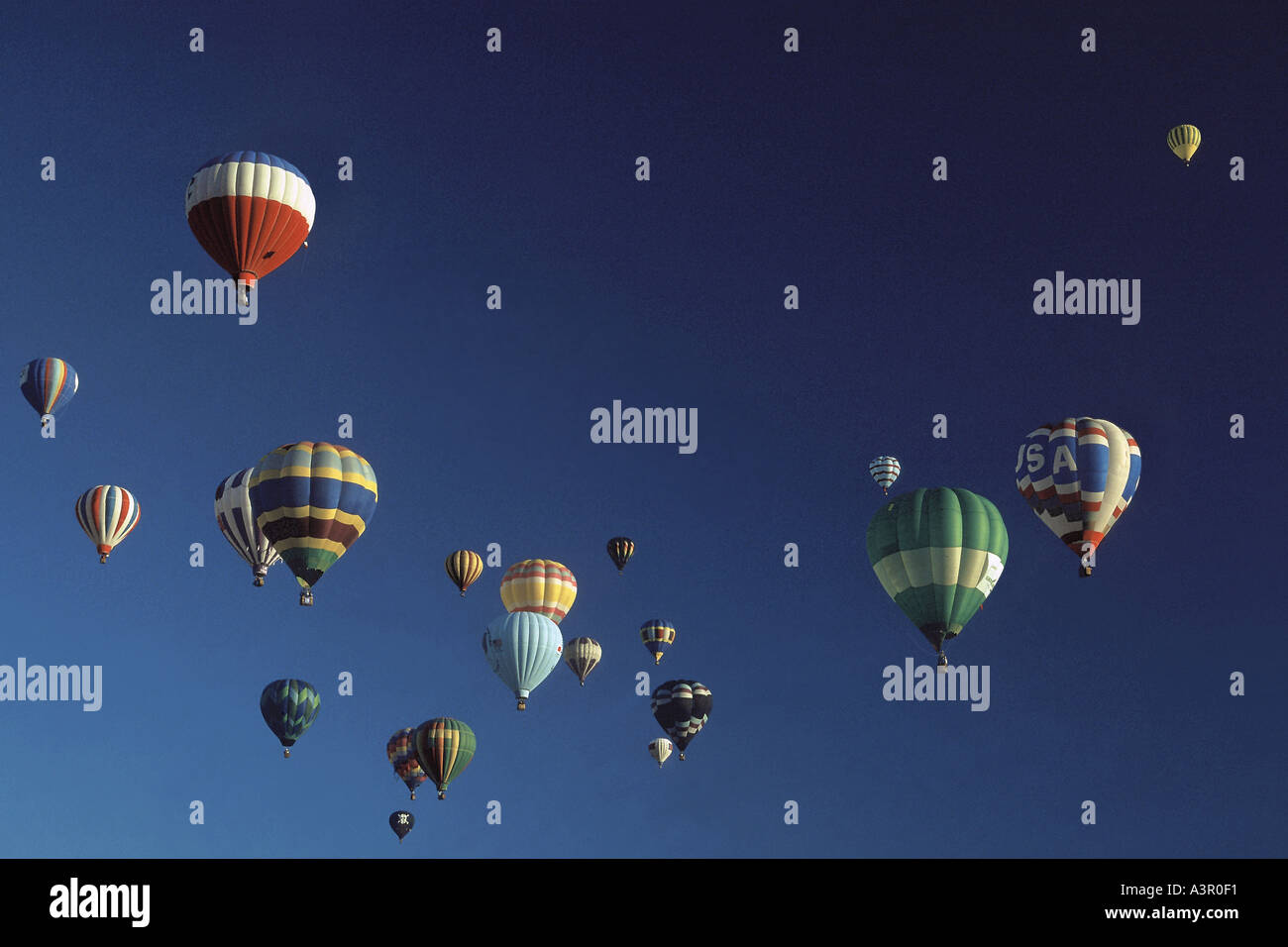 A cluster of balloons peacefully drifting through the sky Stock Photo ...