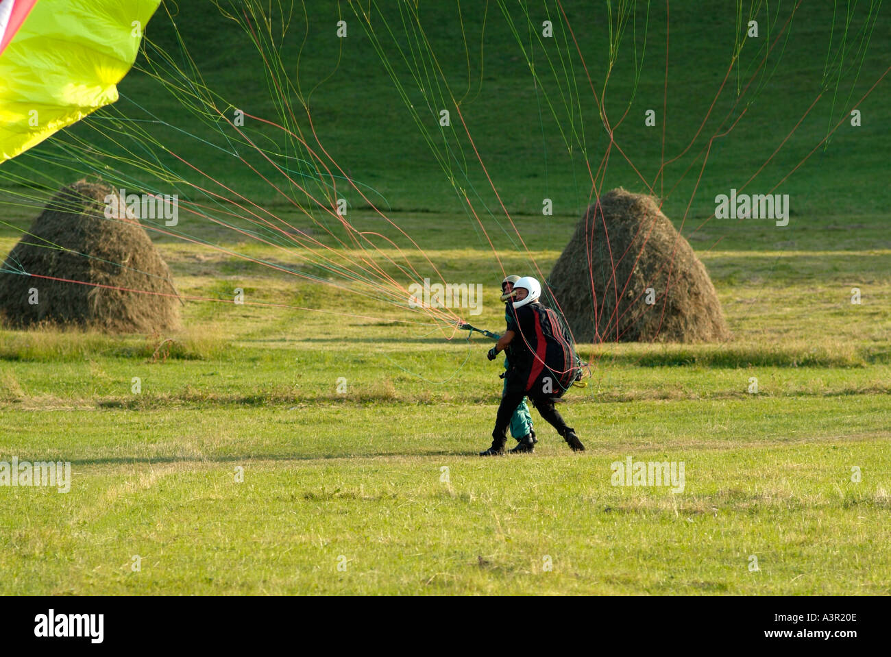 Tandem Paraglider Landing in a Field Stock Photo - Alamy