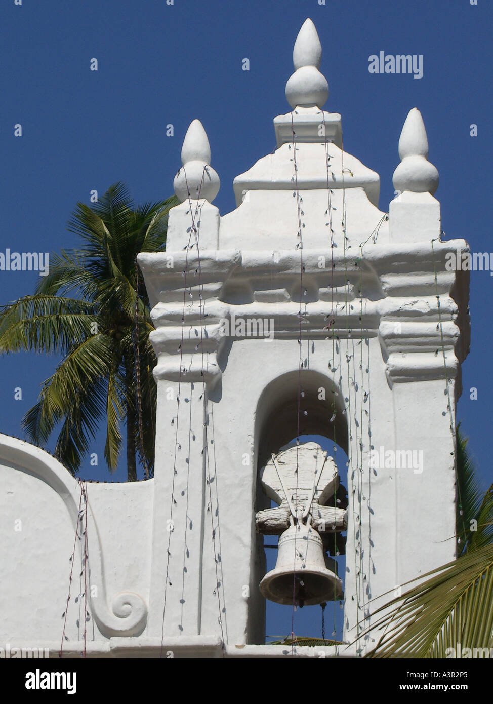 White Christian church tower and coconut tree in the countryside of Goa ...