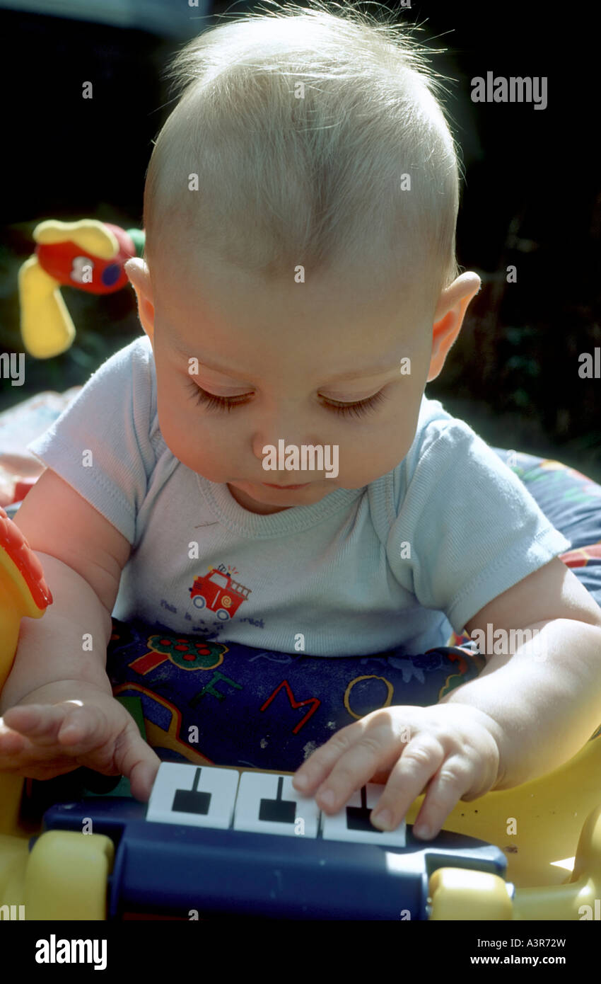 Baby standing in activity center Stock Photo - Alamy