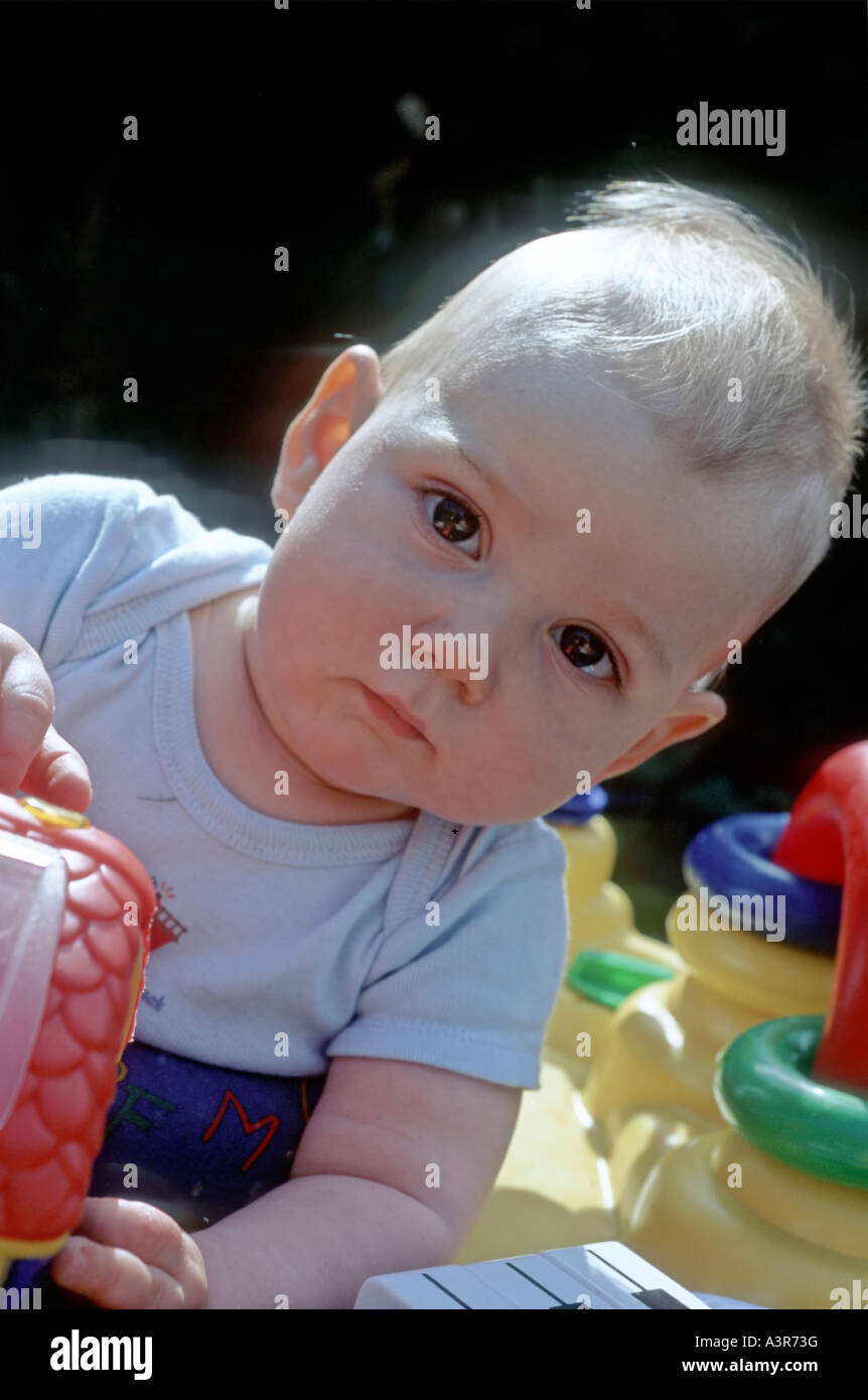 Baby standing in activity center Stock Photo - Alamy
