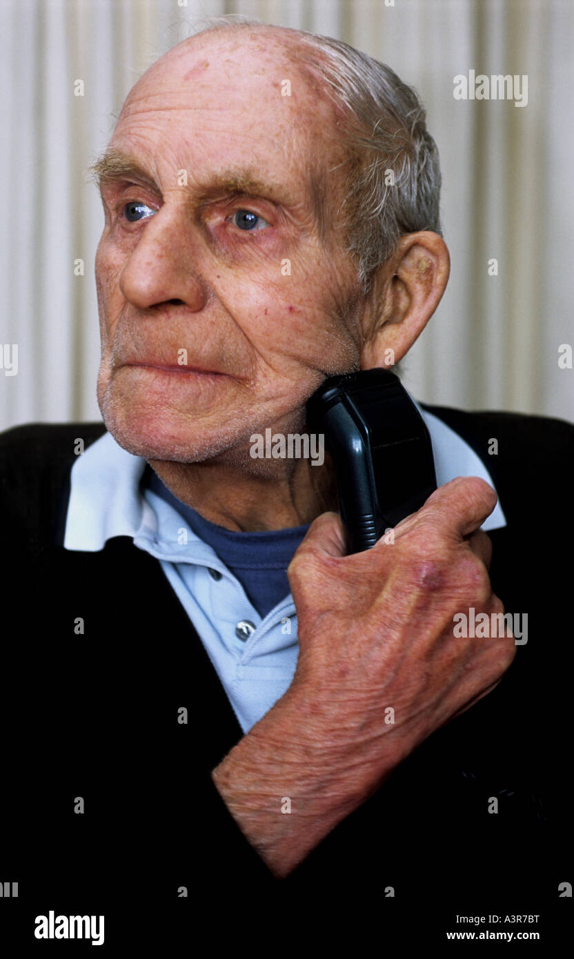 Old age pensioner using an electric shaver at his home in Suffolk, UK ...