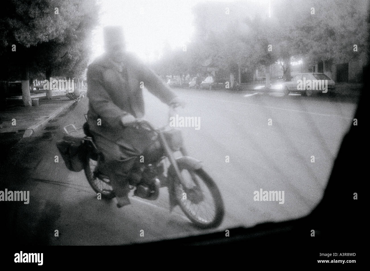 Surreal street scene of a man on a vespa scooter in Ville Nouvelle Fez ...