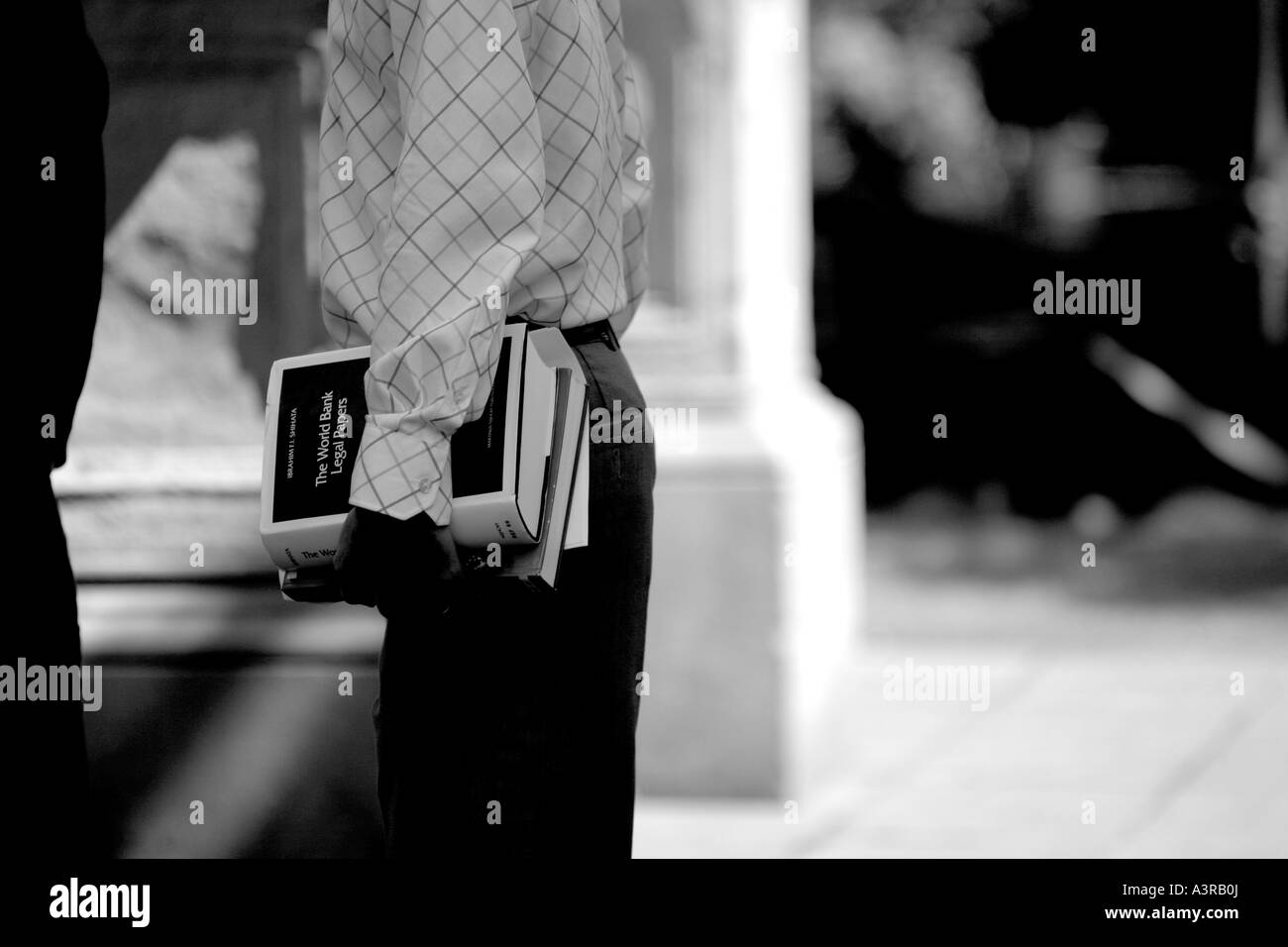 Student with books in his hand standing outside during a free period ...