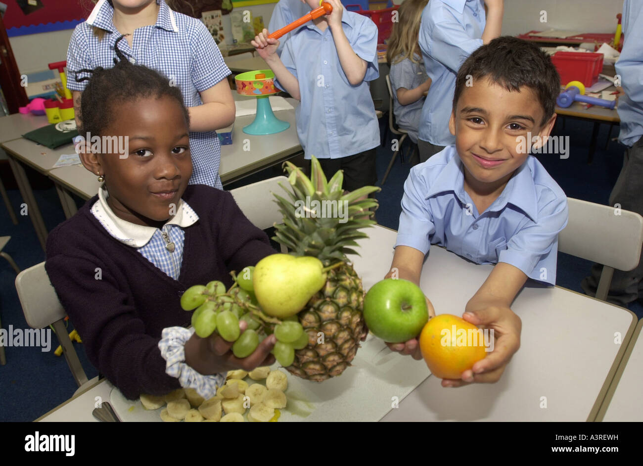 Children show different kinds of fruit in a lesson. Encouraging them to ...