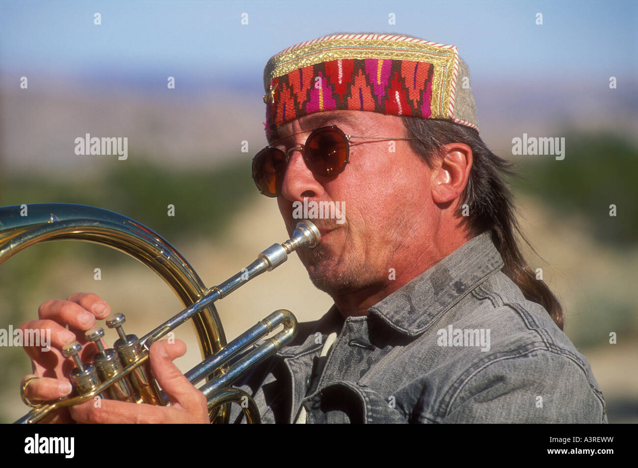 Desert musican with brass instrument, California Stock Photo - Alamy