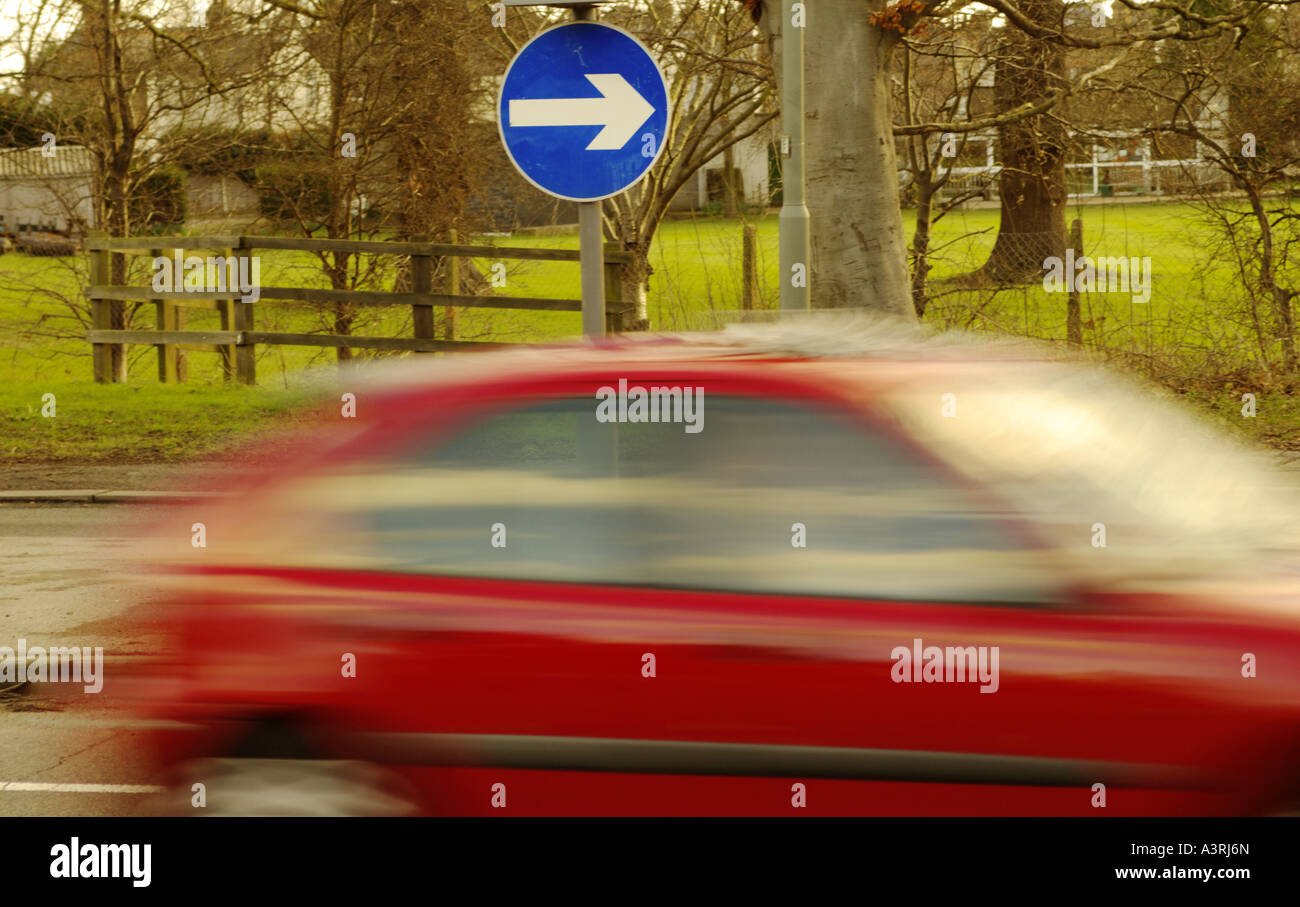 a bright blue turn right one way road sign against a green background ...