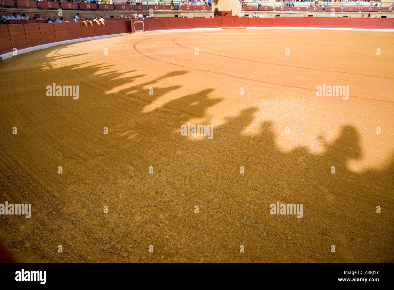 The evening light casting long shadows of spectators on arena of a ...