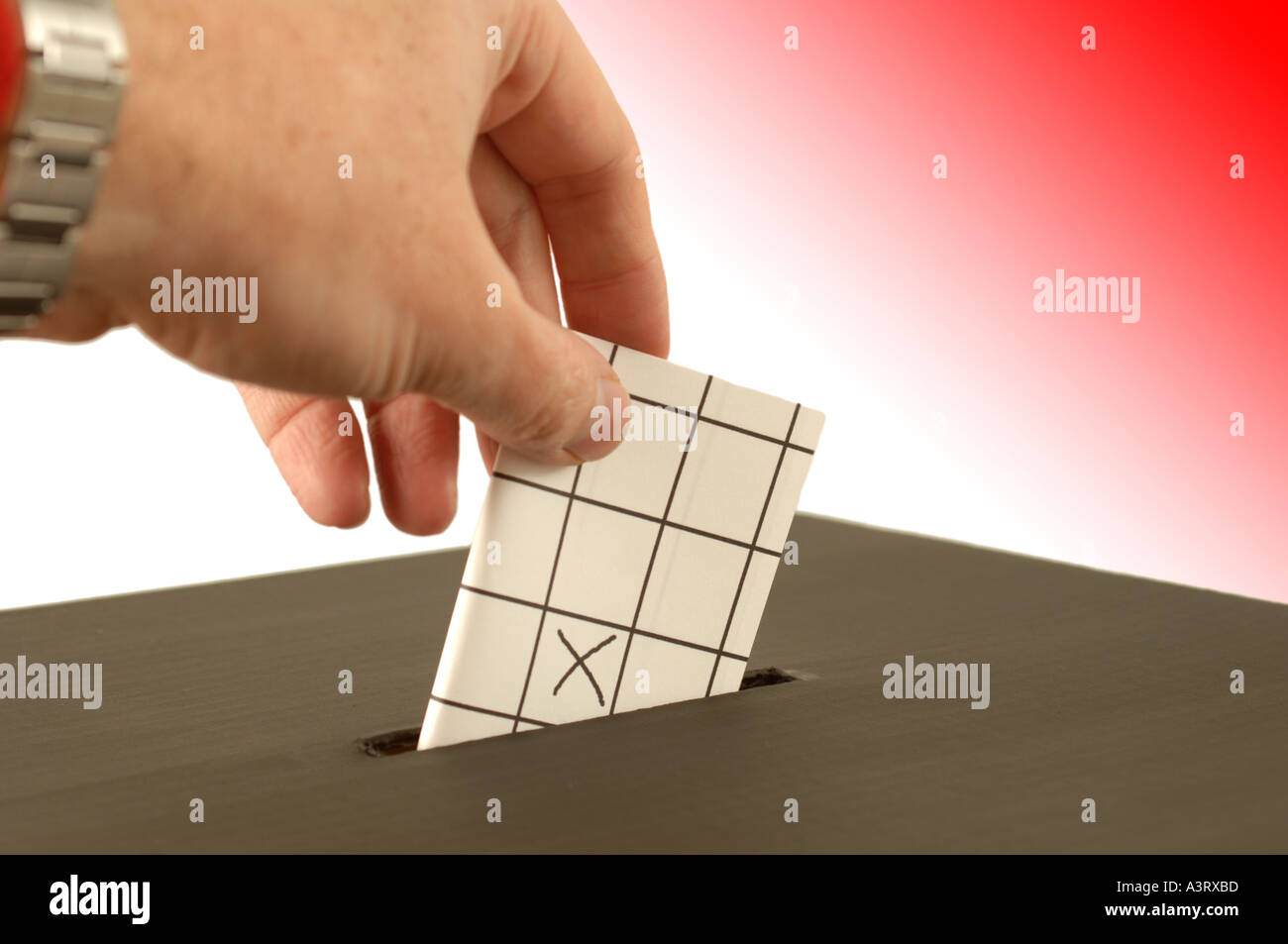 Hand putting a vote into a ballot box Stock Photo - Alamy