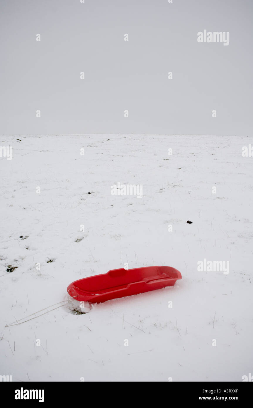 red plastic sledge in the snow Stock Photo - Alamy