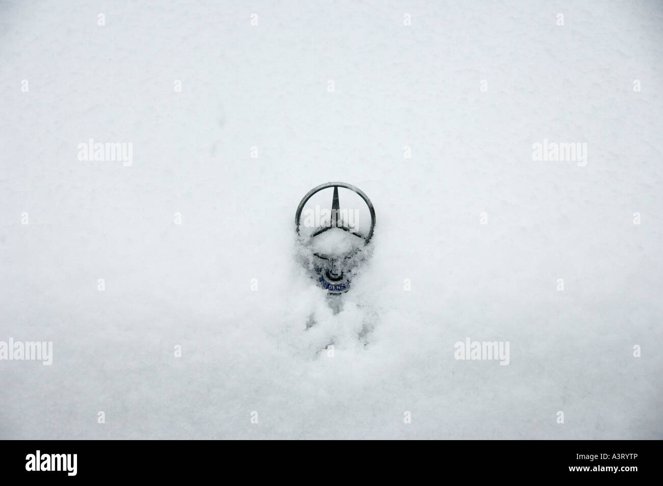 mercedes benz emblem on bonnet of a car covered in snow Stock Photo - Alamy